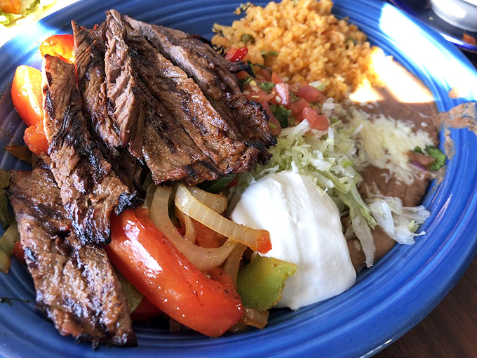 Fajitas that arrive with purpose: tender steak, vibrant peppers, and the promise of DIY deliciousness. That dollop of sour cream is the cool friend in a hot crowd.
