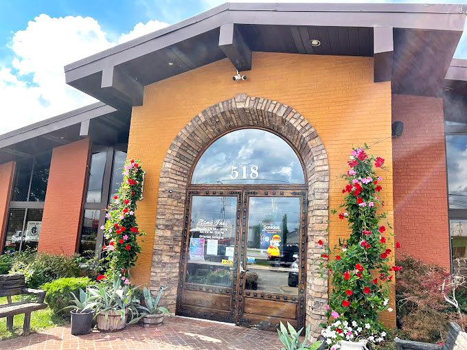 The entrance, framed by vibrant flowers, beckons like a portal to flavor country. Those red blooms aren't just decoration&mdash;they're nature's way of saying "good food here!"