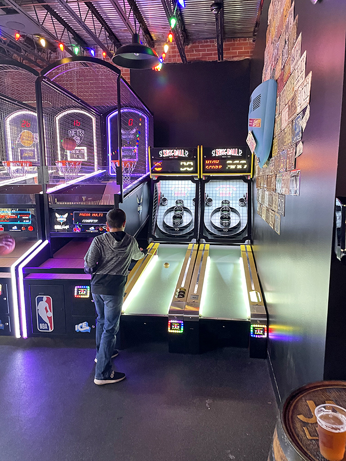 Skee-ball mastery in progress &ndash; this young competitor demonstrates perfect form while embracing the timeless joy of arcade gaming.