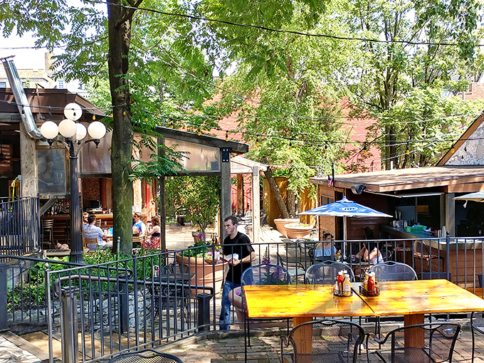 The courtyard dining area whispers "stay awhile" through dappled sunlight and the gentle clinking of glasses among brick-framed greenery.