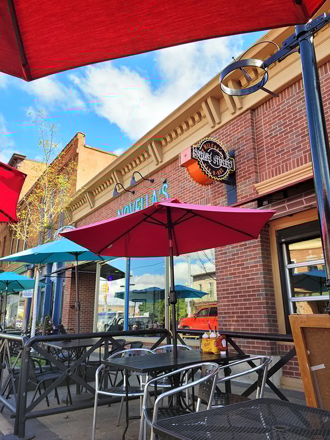 Outdoor dining under Michigan skies, where the red umbrellas pop against brick walls and barbecue dreams come true.