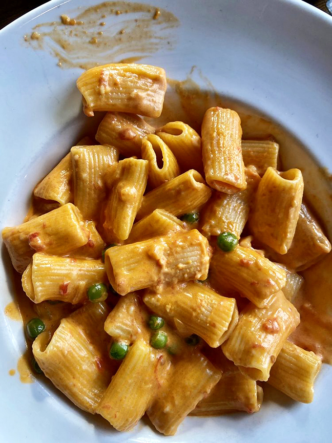 Rigatoni vodka with sweet peas playing hide and seek – pasta that makes you want to hug whoever invented comfort food.