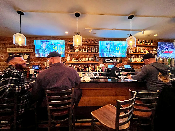 The bar scene where strangers become friends over shared oyster platters. Brick walls and pendant lights create the perfect backdrop for seafood confessions.
