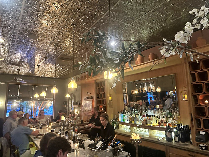The ornate ceiling reflects the golden glow of pendant lights while the bar buzzes with energy. This isn't just dinner &ndash; it's dinner and a show.