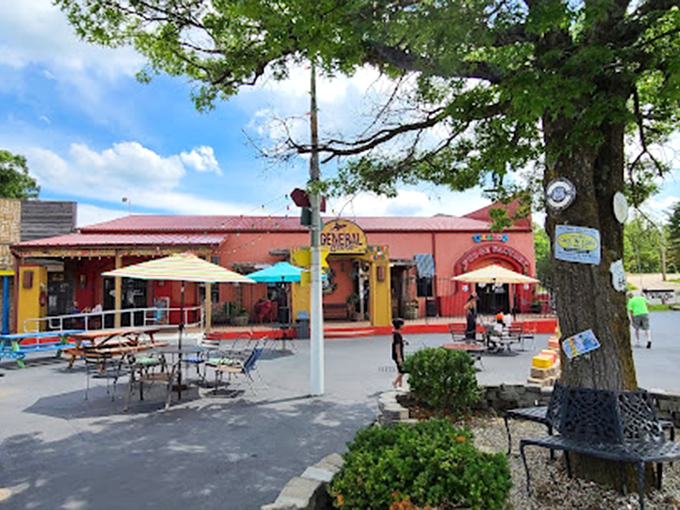 Cheerful umbrellas shade outdoor tables where visitors can savor their treats. The red building with its distinctive arches creates a memorable landmark along Route 66.