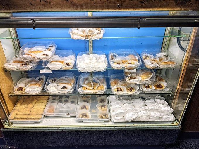 The dessert case&mdash;a glass-enclosed museum of sweet temptation where willpower goes to die and "I'll just have a bite" becomes fiction.
