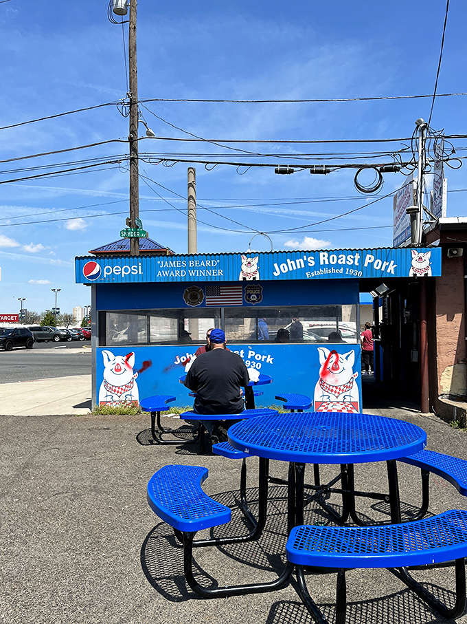 Outdoor seating with industrial charm. The blue tables say, "Sit here and prepare for a life-changing sandwich experience."