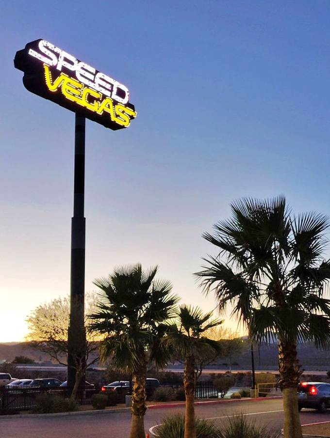 The "Speed Vegas" sign glows against the desert sunset, beckoning thrill-seekers like a neon lighthouse for adrenaline junkies.