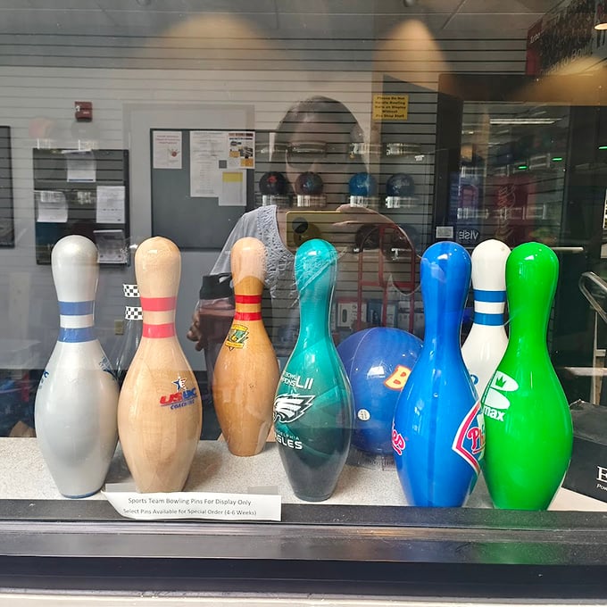 Sports team bowling pins stand at attention in their display case, like tiny ambassadors from Philadelphia's athletic universe.