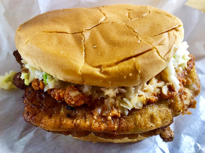 Tender fried meat spilling gloriously beyond its bun boundaries - the kind of sandwich that requires strategic eating and extra napkins.