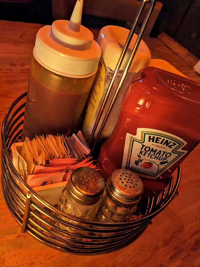 The condiment caddy waits patiently, though the truly enlightened know this burger requires minimal embellishment to shine.