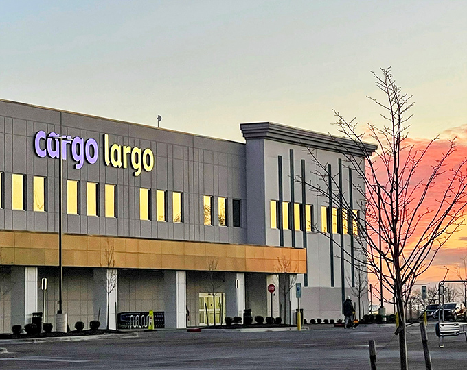 As evening falls, Cargo Largo's illuminated sign beckons bargain hunters like a lighthouse guiding ships to the shores of sweet savings.