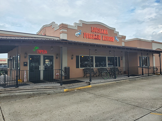 Even in daylight, the salmon-colored exterior stands as a landmark for those seeking authentic Louisiana flavors without the French Quarter prices.