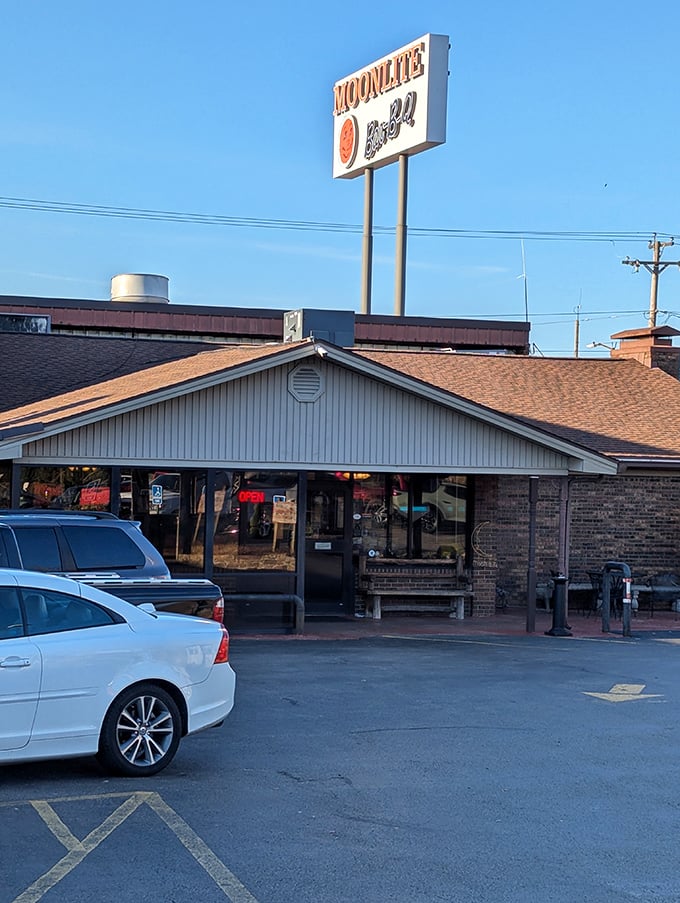 Morning light catches the Moonlite sign, promising another day of barbecue excellence. Some people plan entire road trips around this very destination.