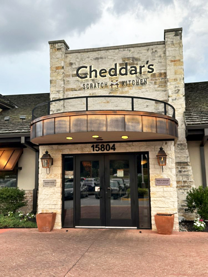 The stone facade entrance says "rustic charm" while the address says "yes, we're in a suburban strip mall, and we're owning it."