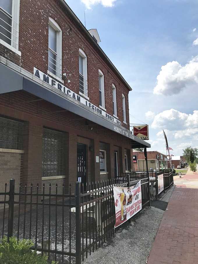 Sunny-day perspective of this humble brick building with its simple sign &ndash; proving that extraordinary food experiences often hide in plain sight.