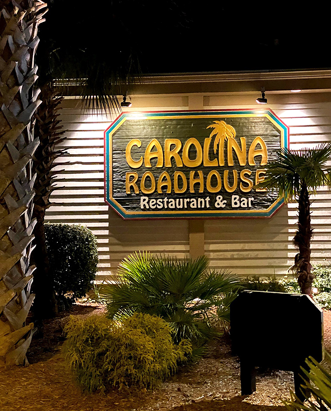 As night falls, the Carolina Roadhouse sign glows like a beacon, guiding hungry travelers to their culinary destiny.