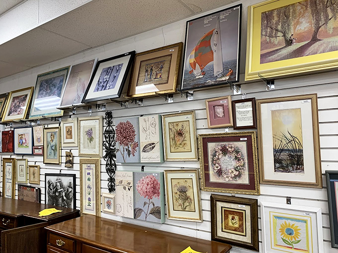 The wall of artwork transforms ordinary retail space into an impromptu gallery where sailboats, landscapes, and still lifes compete for your attention. 