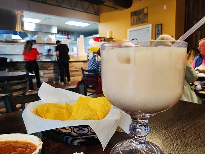 A proper horchata in its goblet throne, standing guard over chips like a creamy, cinnamon-kissed sentinel of refreshment.