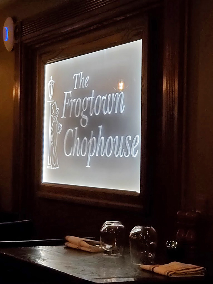 The illuminated sign glows like a beacon for hungry travelers. In the soft light, that dapper frog seems to whisper, "Trust me, you've made the right choice." 