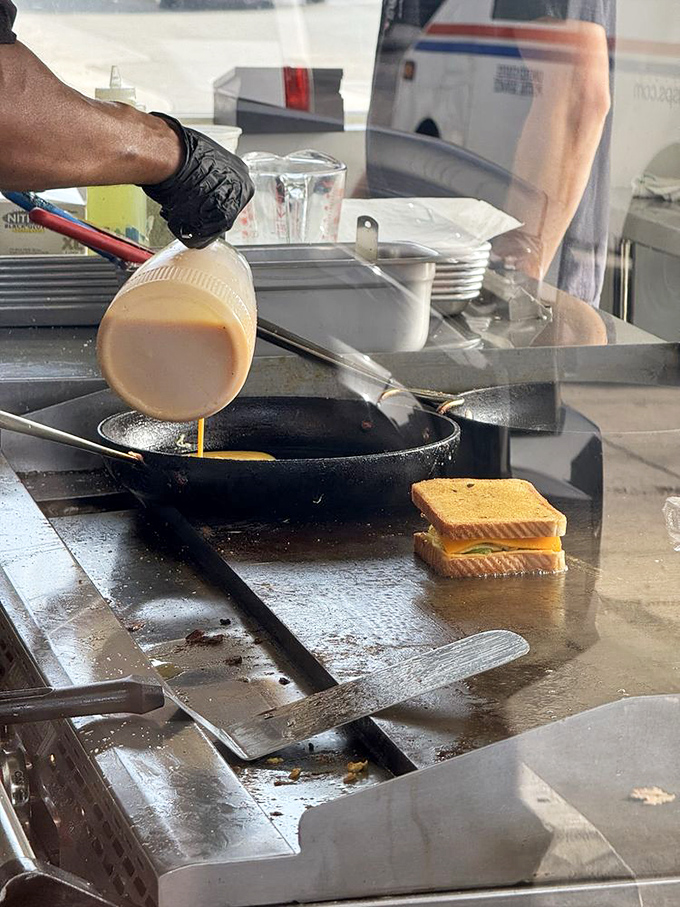 Behind the scenes of sandwich artistry. That egg pour is the breakfast equivalent of a champagne fountain at a fancy wedding.