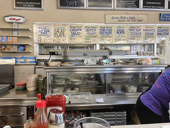 "Service With a Smile... MOST OF THE TIME"—the kitchen area's honest promise that somehow makes you love this place even more.