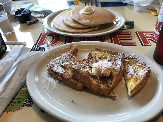 French toast dusted with powdered sugar while pancakes wait patiently in the background. Breakfast's sweet side has never looked more tempting.