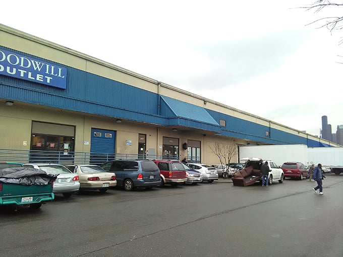 Seattle's skyline peers over the parking lot, as if the city itself is curious about what treasures might emerge from this blue-trimmed warehouse.