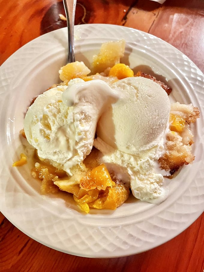 This isn't just peach cobbler&mdash;it's Southern comfort in dessert form, where vanilla ice cream mountains melt into warm fruit valleys.