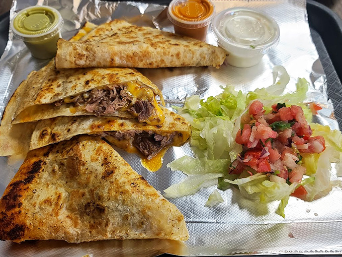 Quesadillas cut with precision, served with fresh pico and a dollop of sour cream&mdash;proof that perfection doesn't require complexity, just attention to detail.