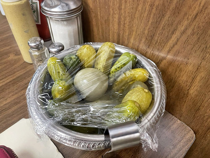 The pickle plate&mdash;that perfect palate cleanser between bites of sandwich, glistening with brine and promise. Never optional, always essential.