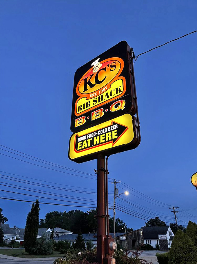 The sign glows like a barbecue lighthouse against the twilight sky, guiding hungry travelers to their smoky salvation.