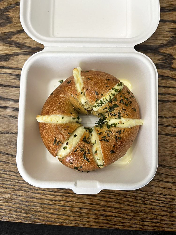 A stuffed garlic bagel that's having an identity crisis as a savory donut. The cheese oozing from within is nature's perfect lava flow.