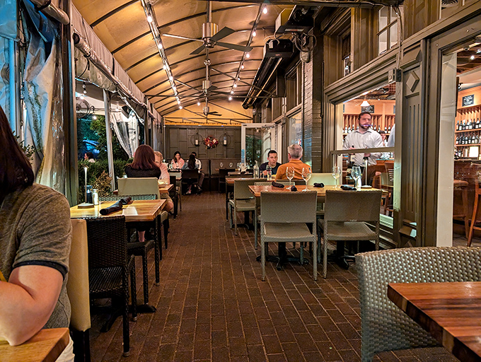 Evening transforms the patio into an intimate escape—brick, wood, and soft lighting creating the perfect stage for memorable meals.