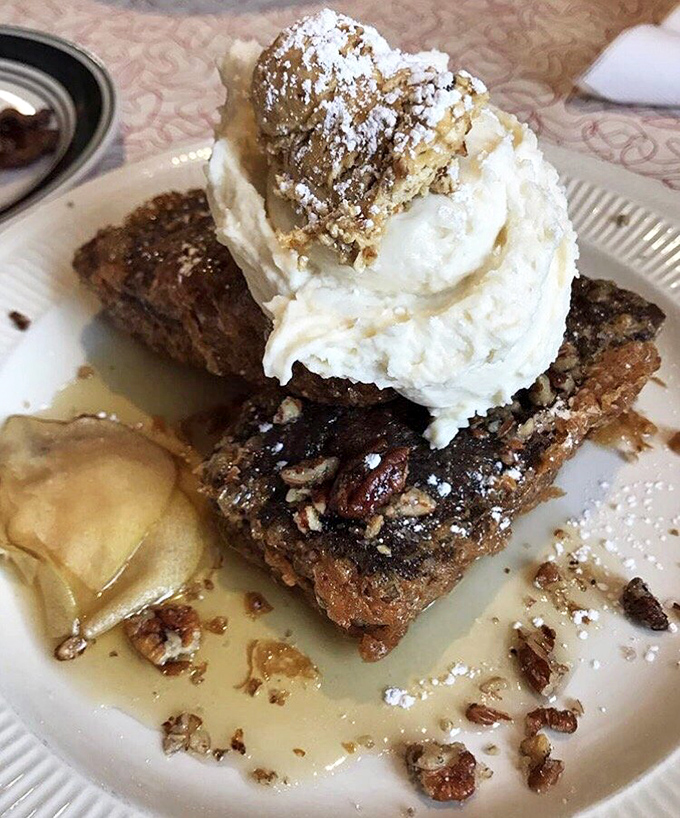 Banana bread French toast that makes regular French toast question its life choices. Topped with whipped cream and what appears to be candied nuts, it's breakfast disguised as dessert.