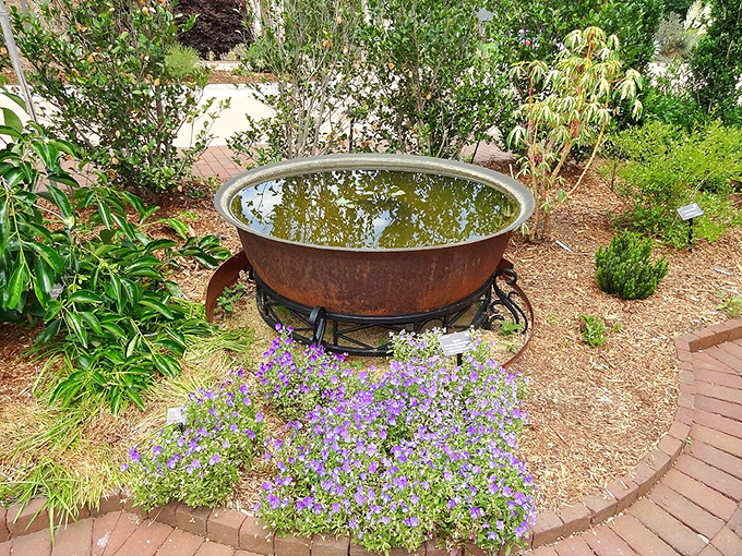 This rustic water feature surrounded by purple blooms creates a moment of zen&mdash;proof that sometimes the simplest elements create the most magic.