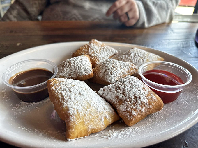 These beignets look like little powdered pillows of joy that arrived with their own swimming pools of sauce for your dipping pleasure.