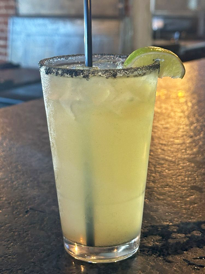 A proper margarita with salt-rimmed attitude and a lime wedge hat. This isn't just a drink&mdash;it's vacation in a glass, no passport required.