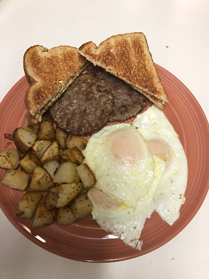 Breakfast of champions &ndash; where the eggs, potatoes, and burger create a holy trinity of morning perfection on a coral-colored plate.