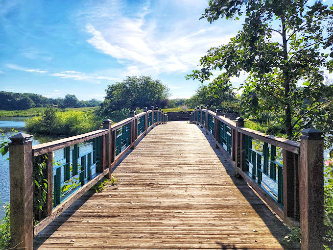 This wooden bridge doesn't just connect two shores—it spans the gap between everyday life and the tranquil escape we all occasionally need.