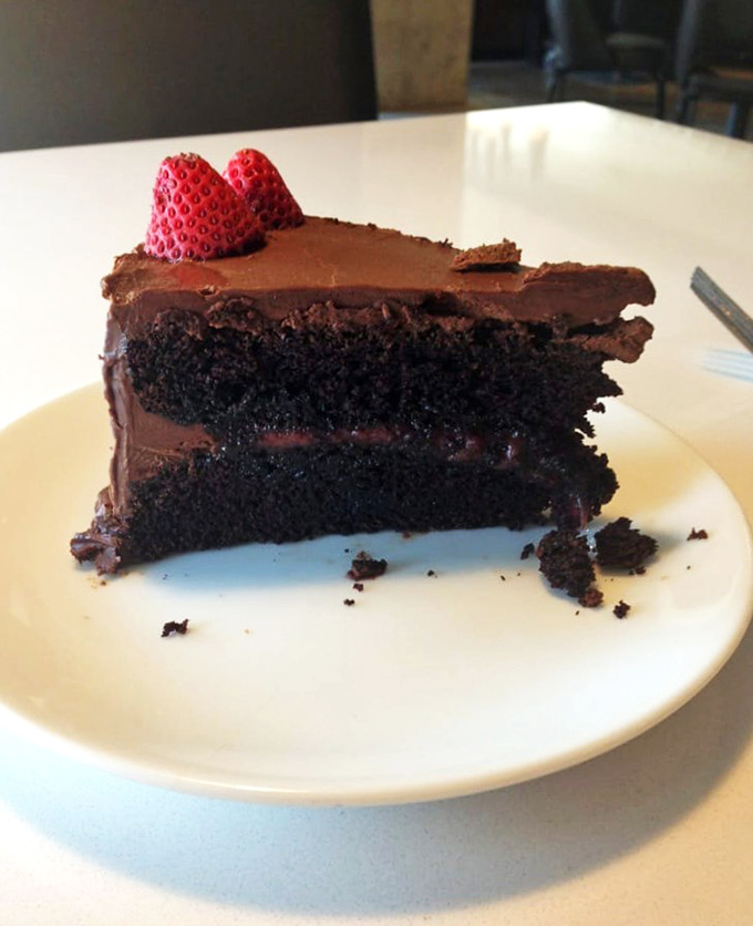 A chocolate cake so dark and rich it could finance its own retirement. Those two strawberries aren't decoration&mdash;they're there to make you feel virtuous.
