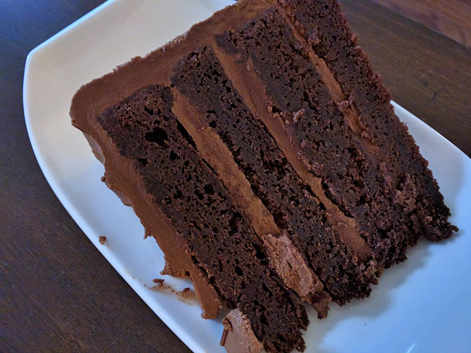 A slice of chocolate cake so rich it should have its own tax bracket. The kind of dessert that makes you consider skipping dinner.