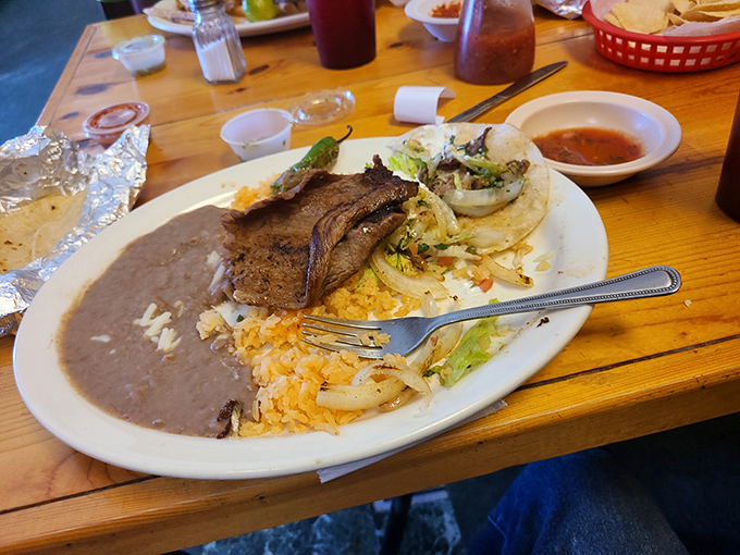 The carne asada platter arrives like a choose-your-own-adventure book—grilled steak, warm tortillas, and all the fixings to create your perfect bite.