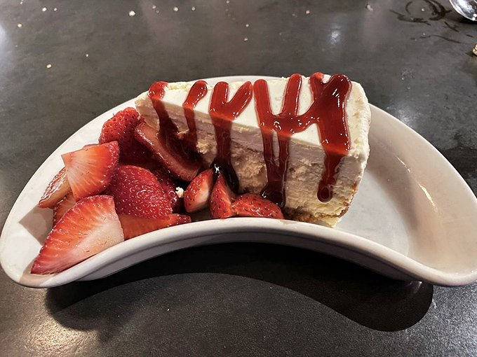 Cheesecake with strawberries and a dramatic sauce drizzle&mdash;because some desserts understand the importance of making an entrance.