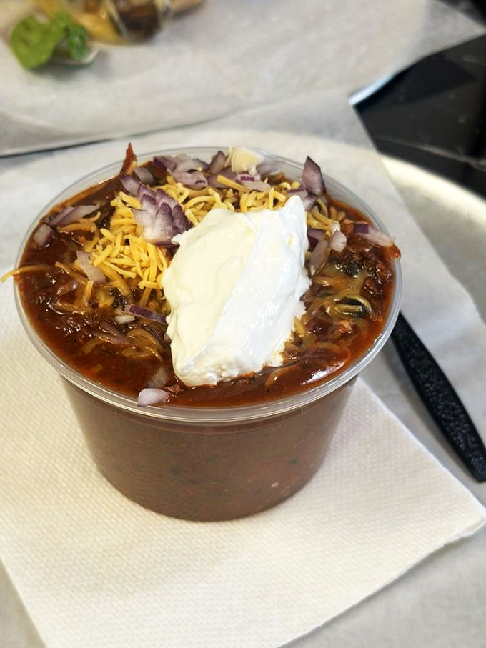 This isn't just chili&mdash;it's a warm hug in a cup, topped with cheese, onions, and sour cream like a savory sundae for grown-ups.