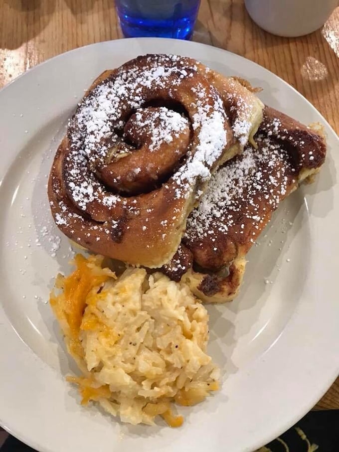 A cinnamon roll that understands its purpose in life is to be excessive in all the right ways, dusted with powdered sugar like fresh mountain snow.