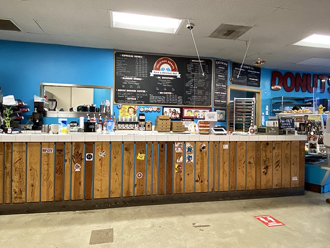 The counter where dreams come true, one donut at a time. Wood paneling and blue walls create the perfect backdrop for serious donut business. 