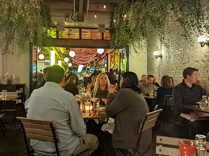 The dining room where hanging plants create nature's chandelier. Conversations flow as freely as the wine in this brick-walled sanctuary.