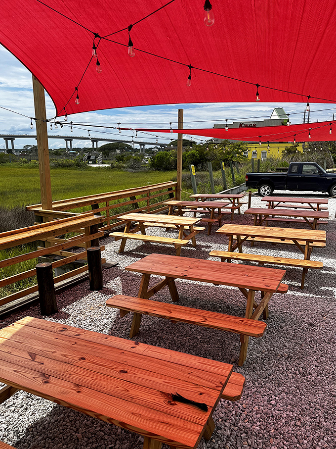 Those red sail shades aren't just practical&mdash;they cast a magical glow over every table, turning an ordinary lunch into coastal theater.