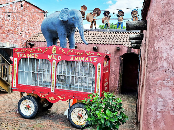 A blue elephant perched atop a vintage circus wagon adds to the roadside wonder. This whimsical touch exemplifies the attraction's commitment to unexpected visual delights.